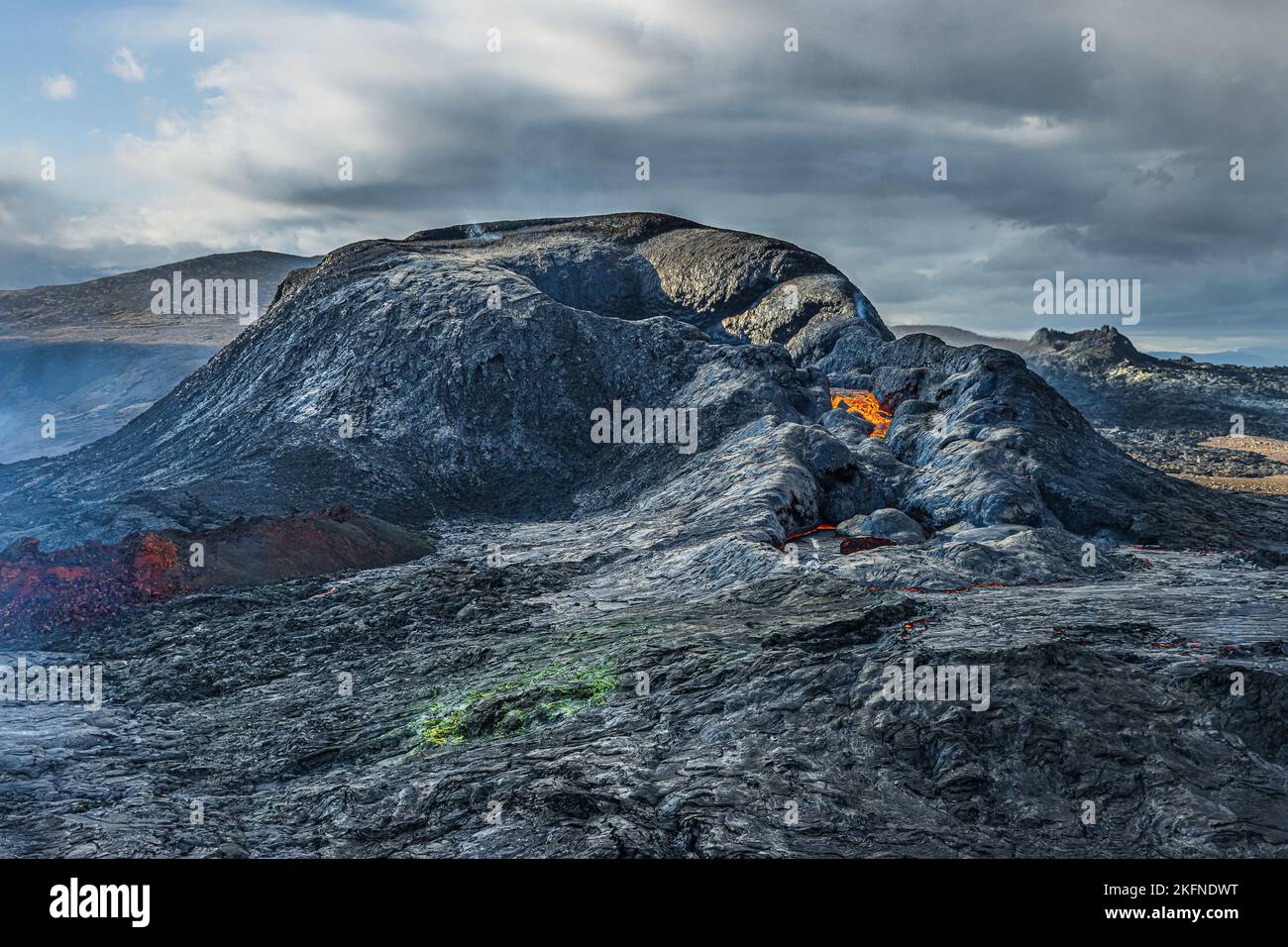 volcanic crater during the day with some lava in the crater mouth ...
