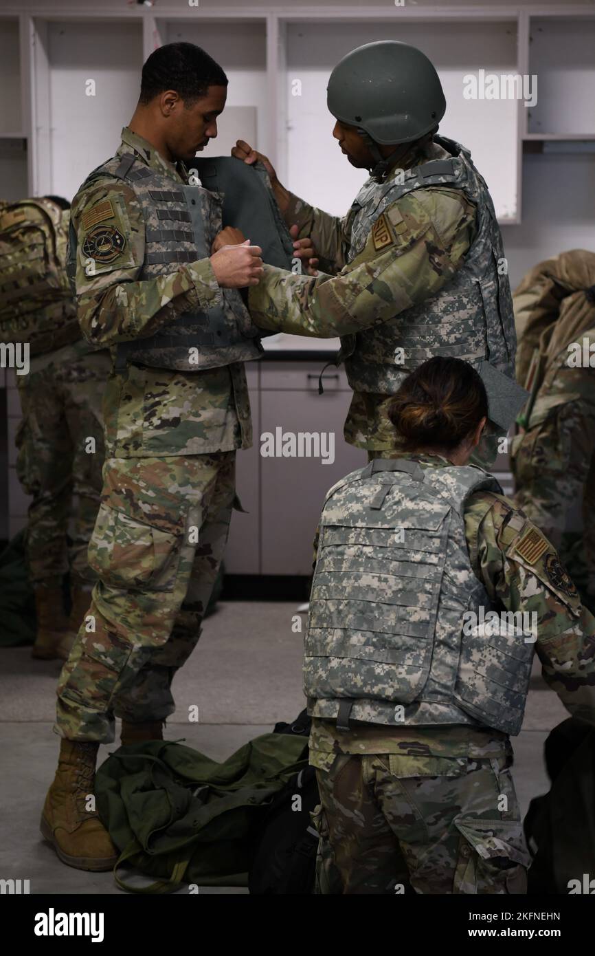 Airmen assigned to the 319th Reconnaissance Wing help don combat gear ...