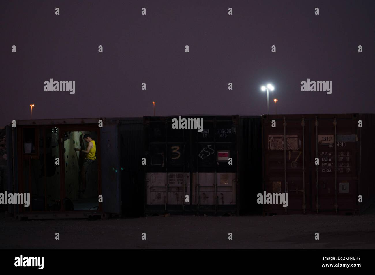 Military personnel climb a rock wall inside a shipping container at Ali ...