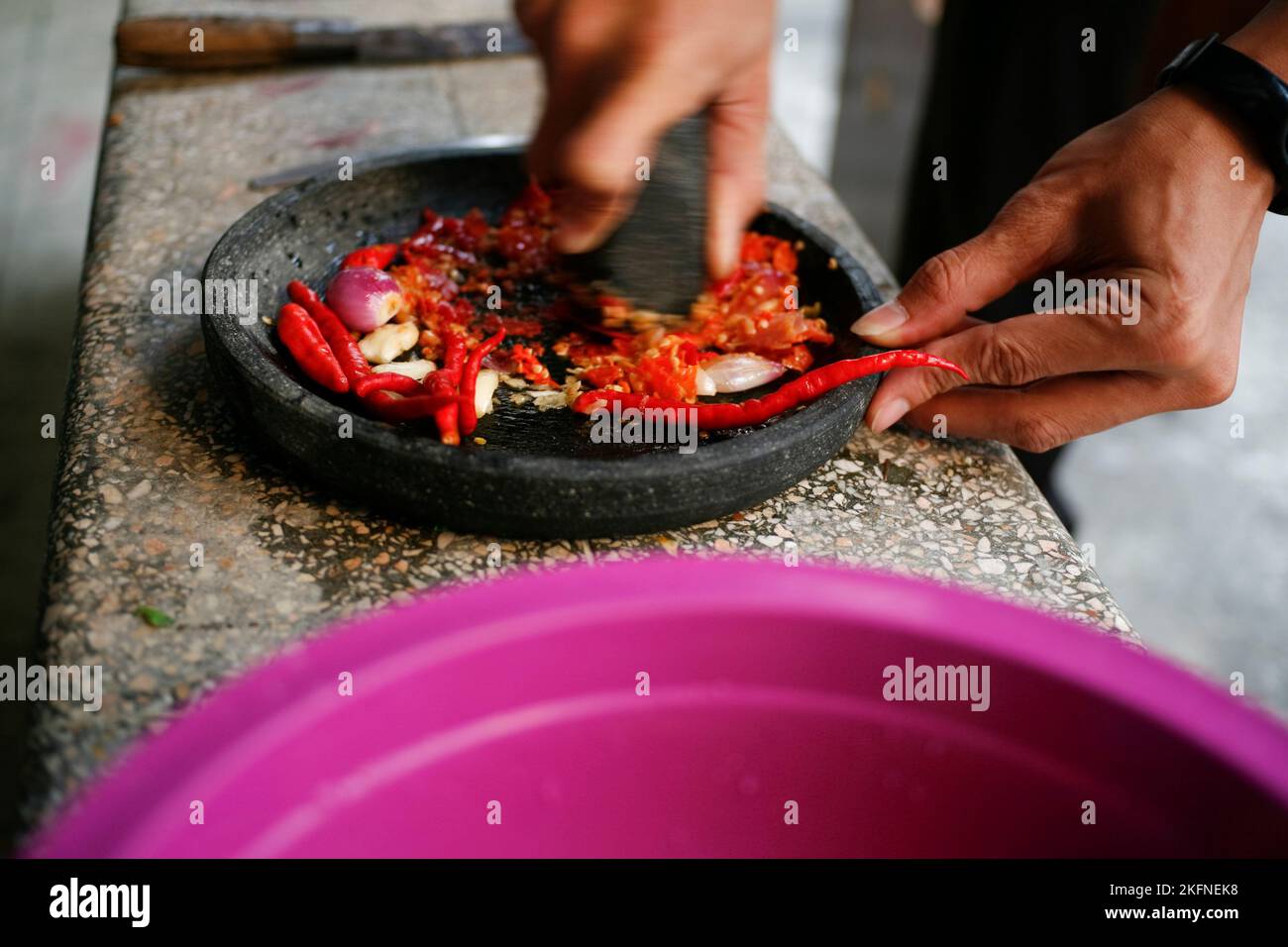 close up hand of a person rubbing the chilli garlic and onion. prepared ...