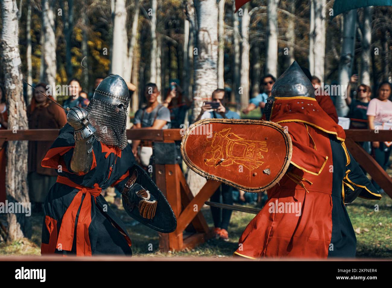 Two knights fight with swords in front of an audience Stock Photo - Alamy