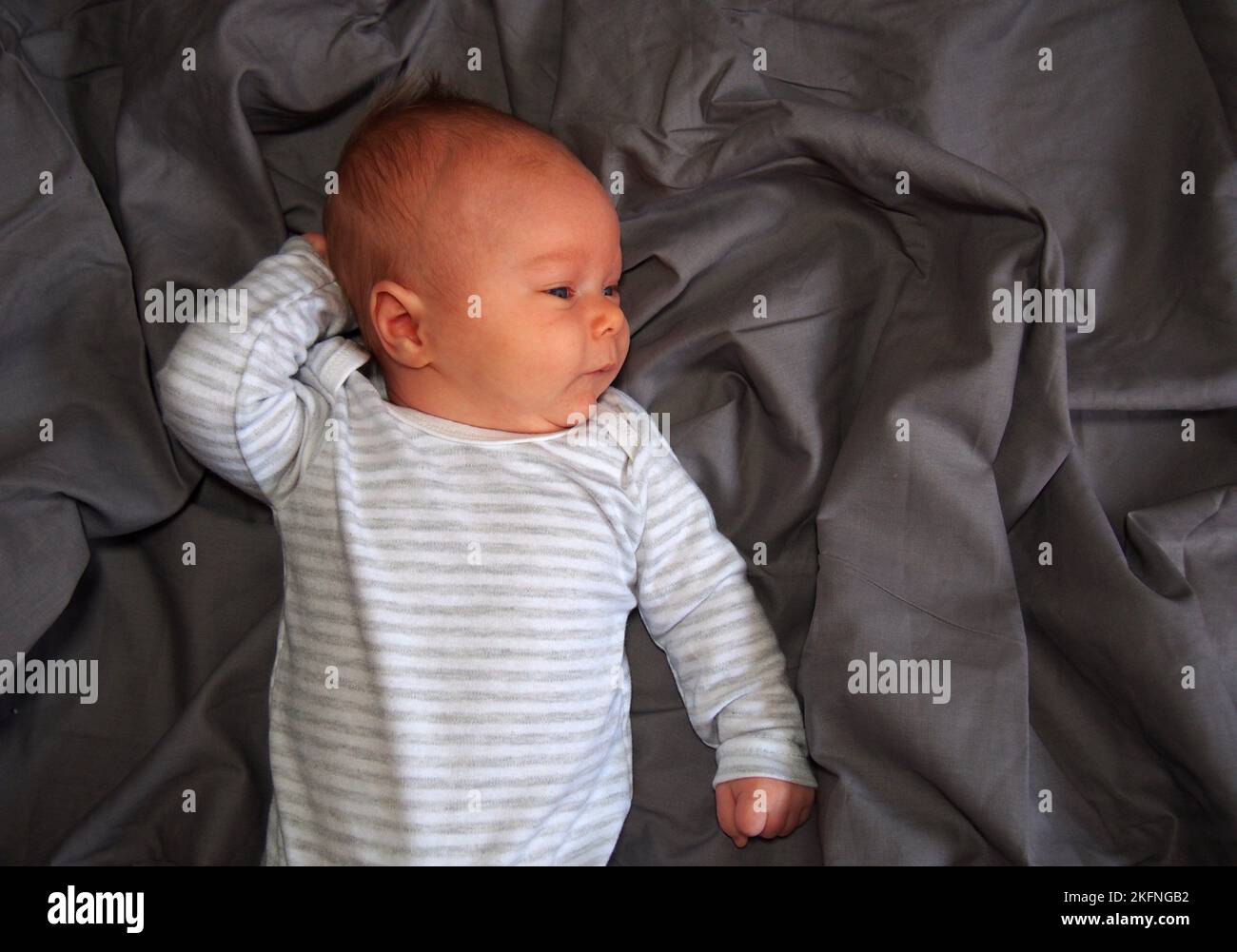 Baby looking right portrait on grey sheet background Stock Photo - Alamy