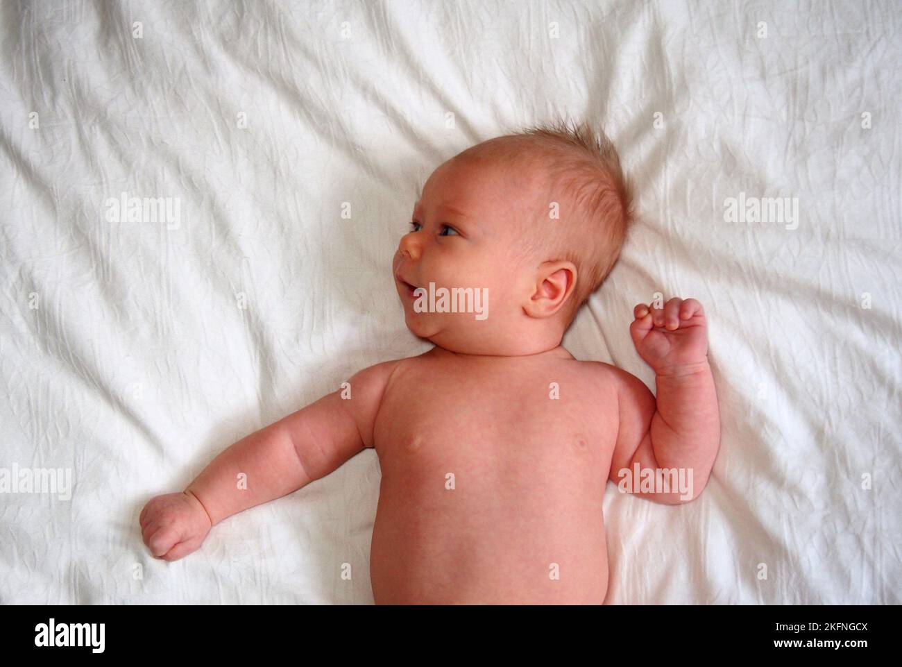 Newborn baby with funny shape of head looking left Stock Photo - Alamy