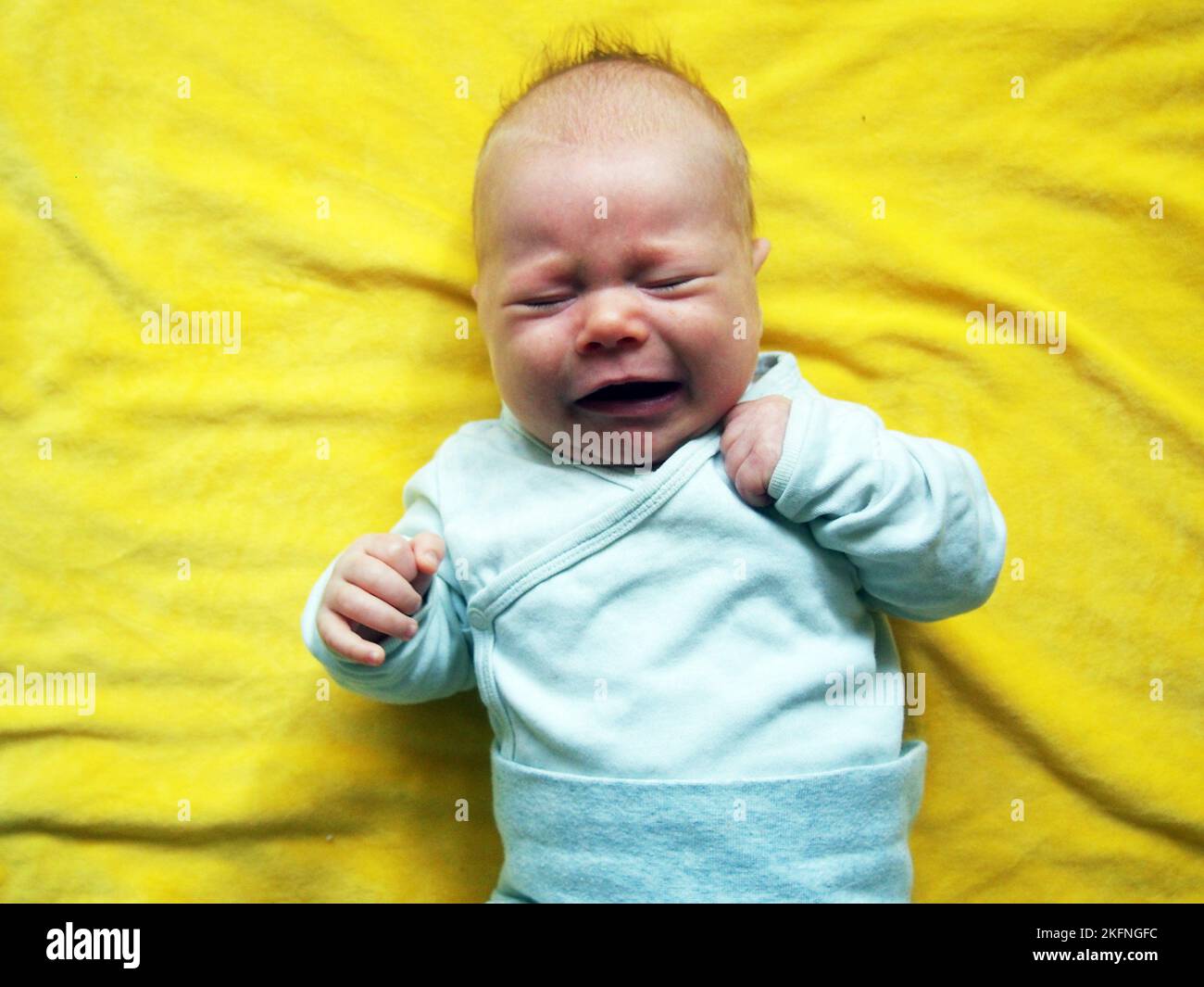 Angry, crying newborn baby on yellow background Stock Photo - Alamy