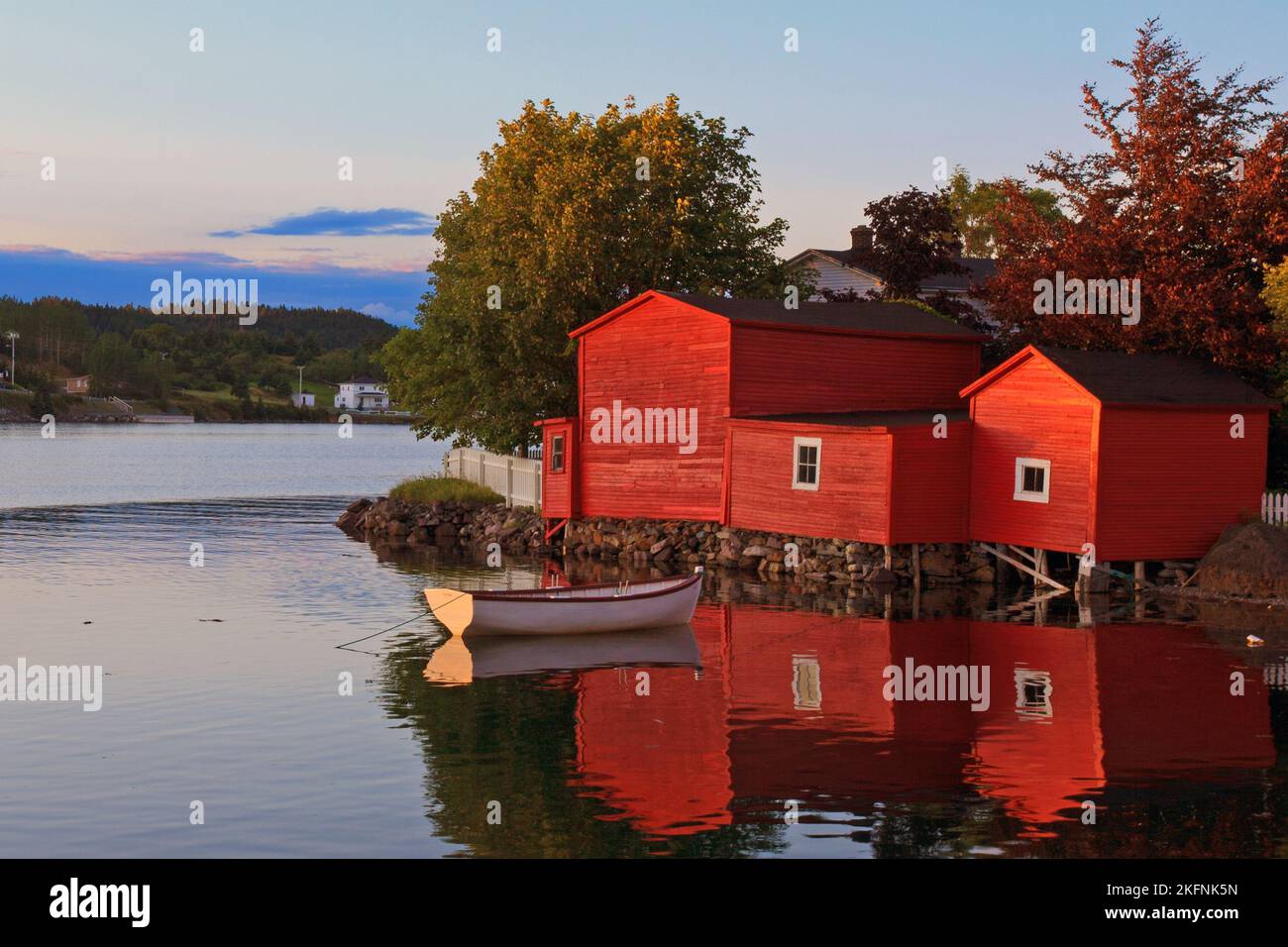 A small boat in a harbor near orange wooden houses Stock Photo - Alamy