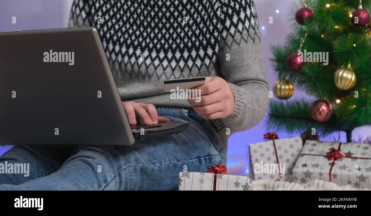 Man with laptop and credit card buys gifts for New Year 2023, Christmas ...