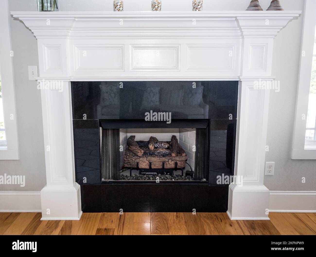 A white detailed ornate wood mantle with a gas fireplace in a new ...