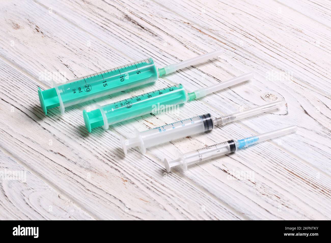Top view of syringes of different sizes on wooden background. Medical ...