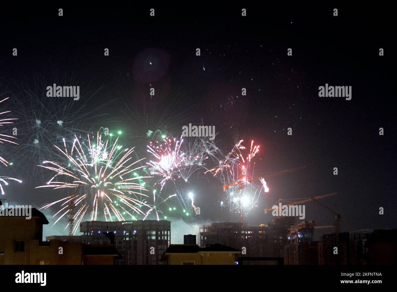 colorful fireworks at night with shadows of a construction site and ...