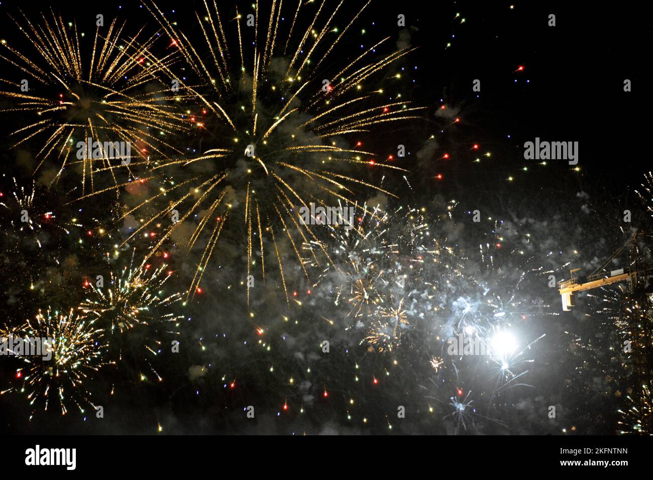 colorful fireworks at night with shadows of a construction site and ...