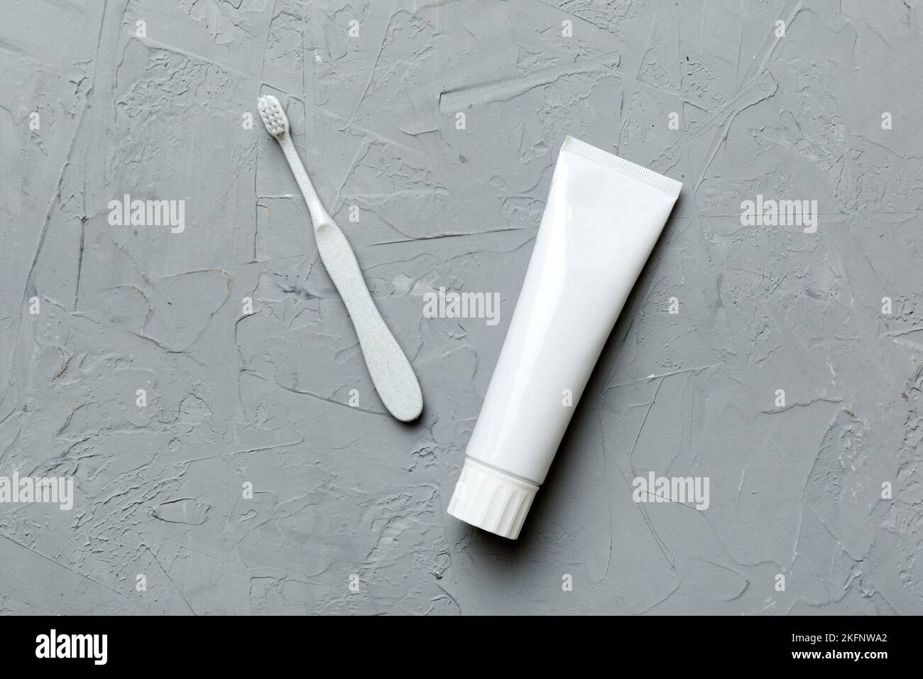 toothpaste and toothbrush top view with copy space on colored ...