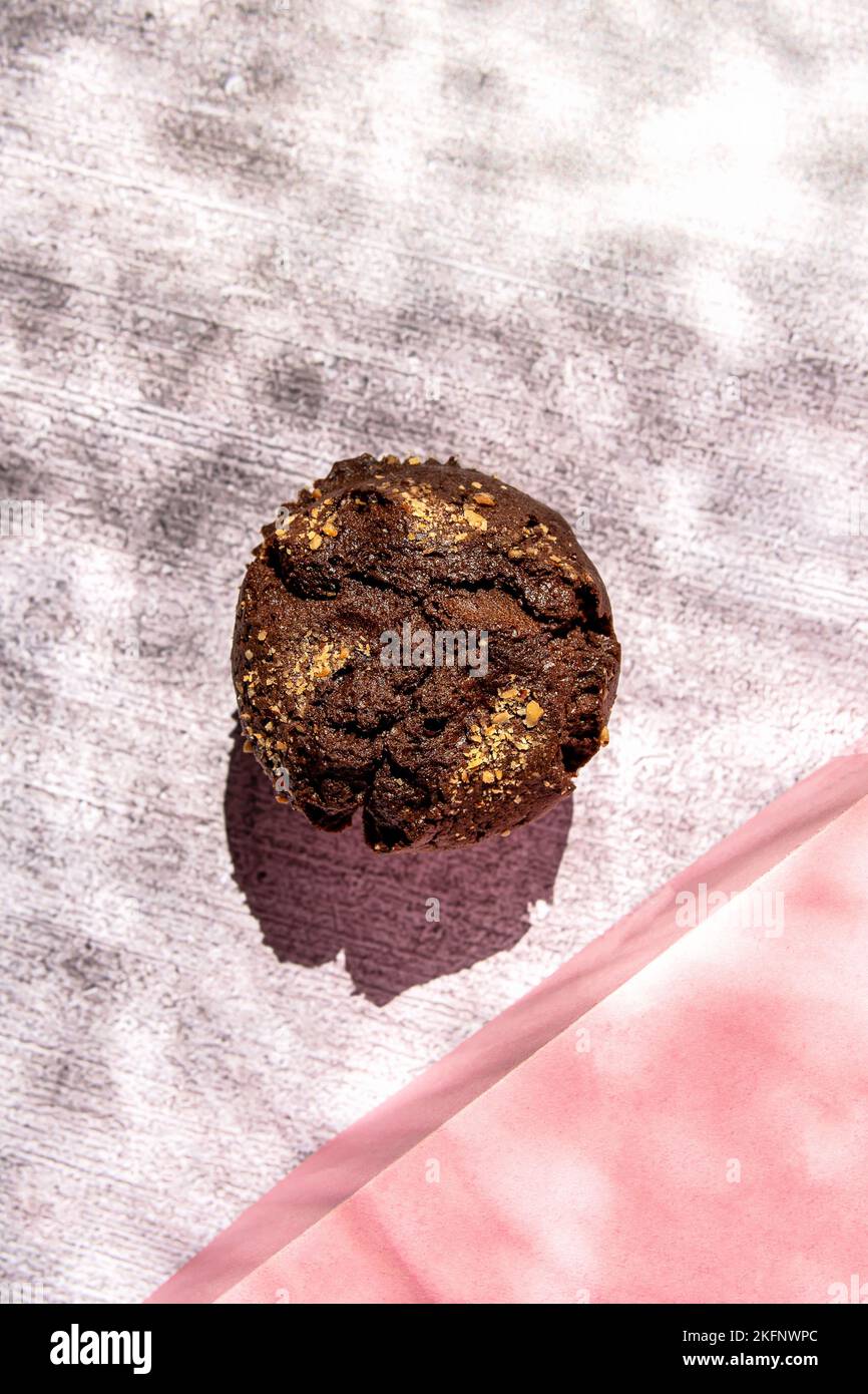 A vertical shot of a delicious chocolate muffin with cinnamon powder on ...
