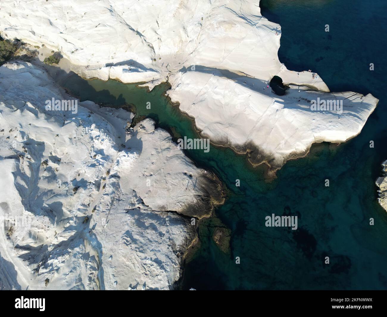 An aerial view of a white rocky coast on an island meeting a crystal ...