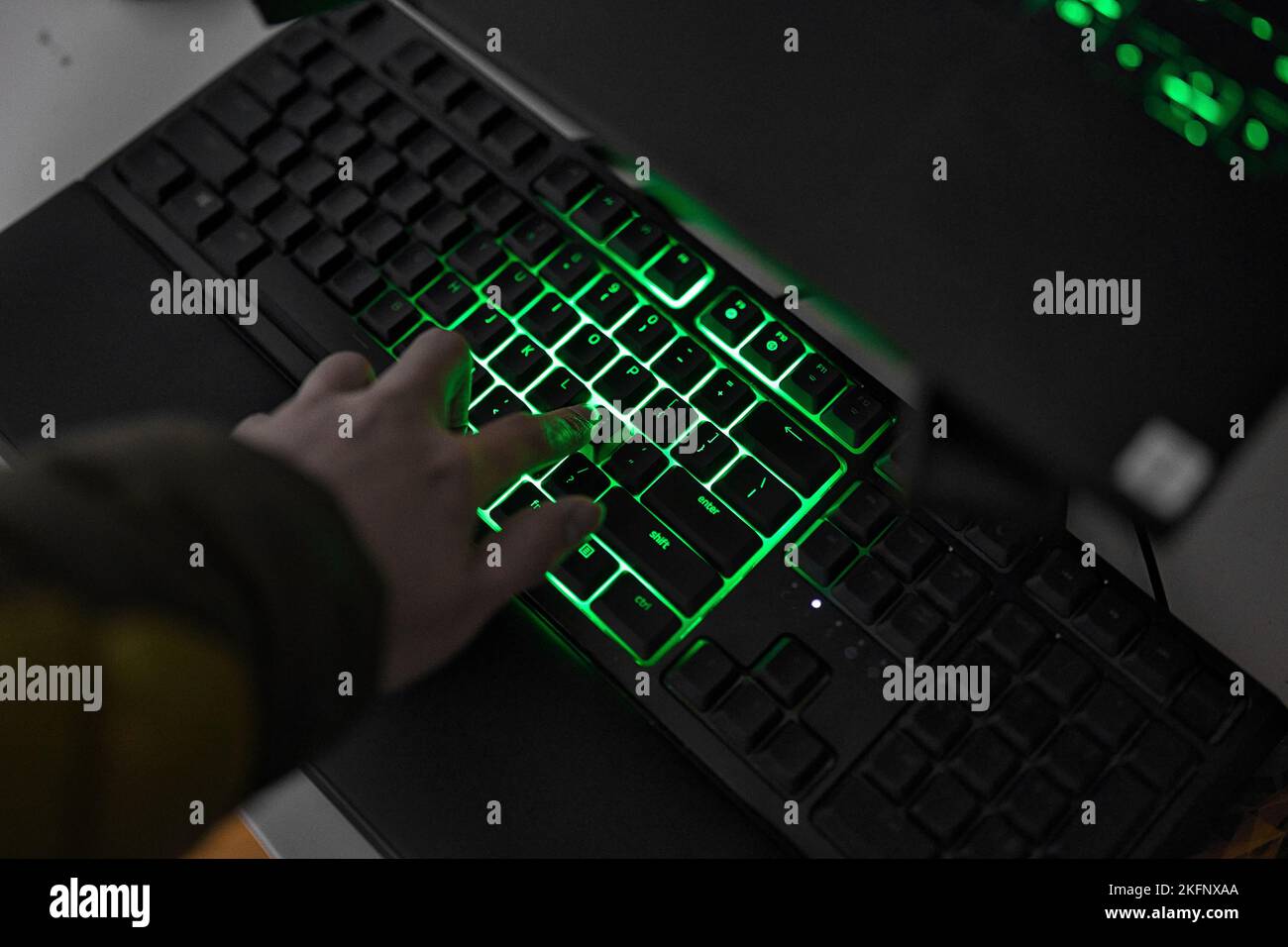 A hand pressing a razer gaming keyboard with bright colourful lights ...