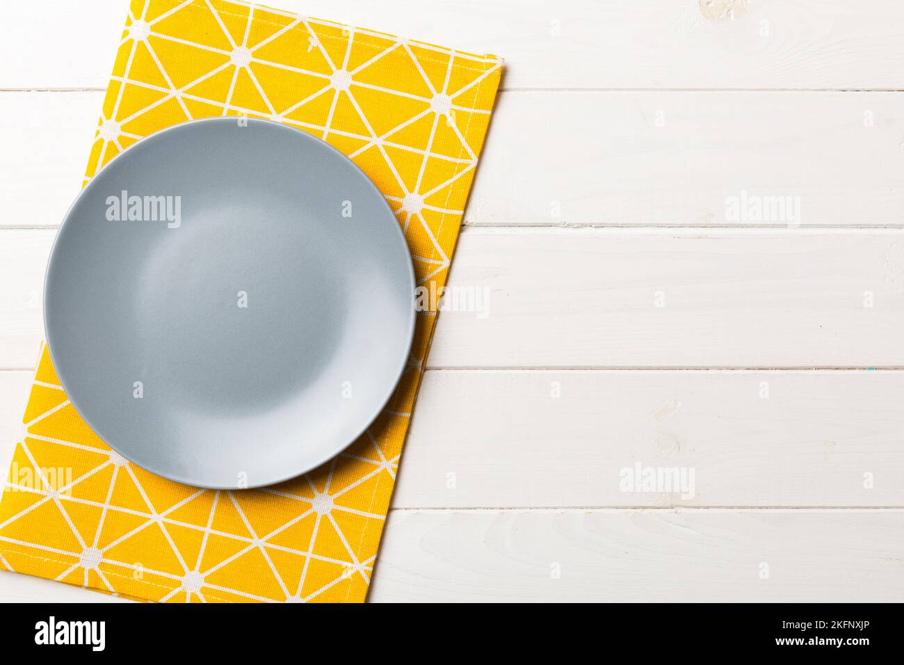 Top view on colored background empty round gray plate on tablecloth for ...