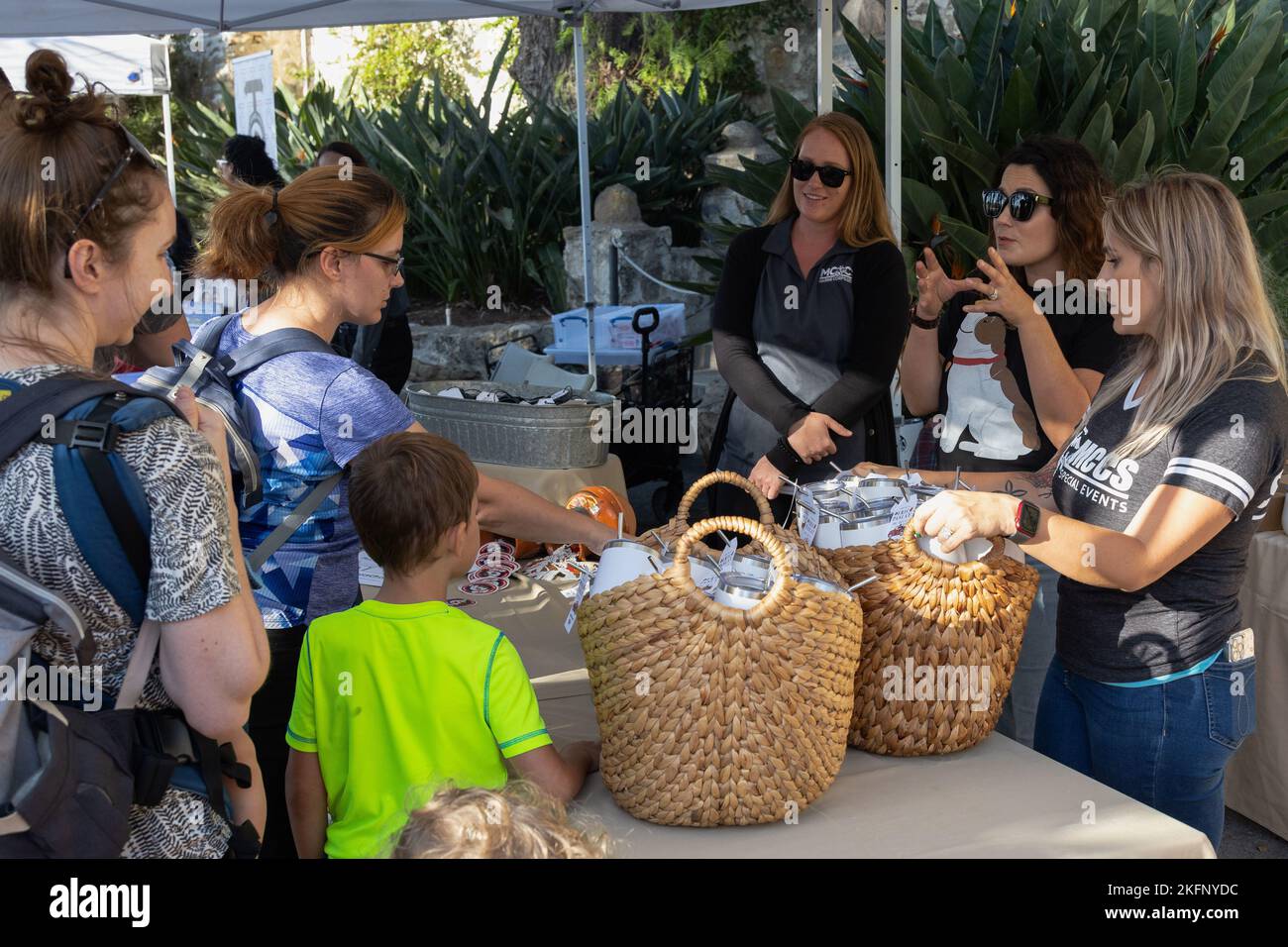 Marine Corps Community Service’s booth vendors speak to a family during ...