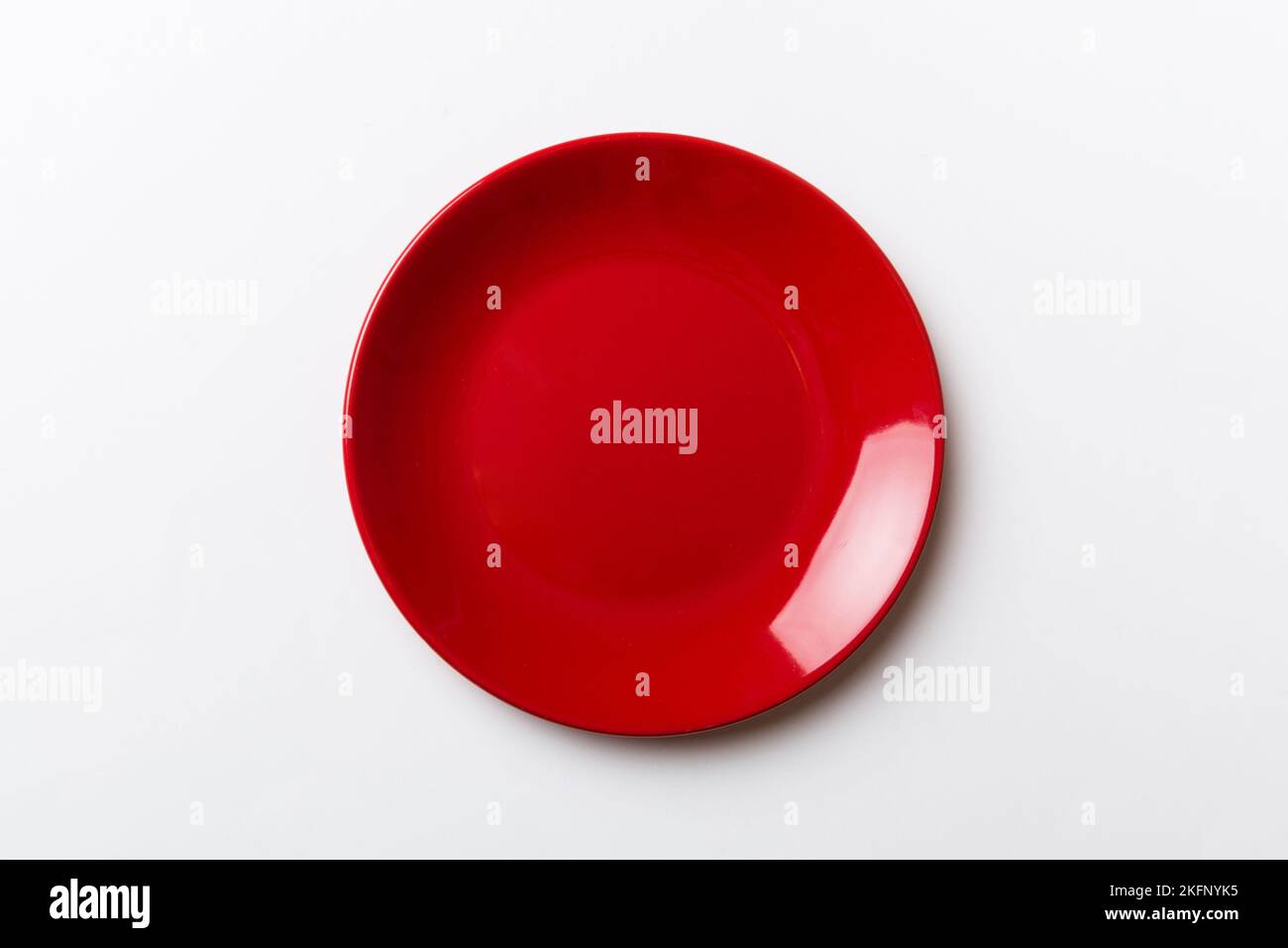 Top view of isolated of colored background empty round red plate for ...