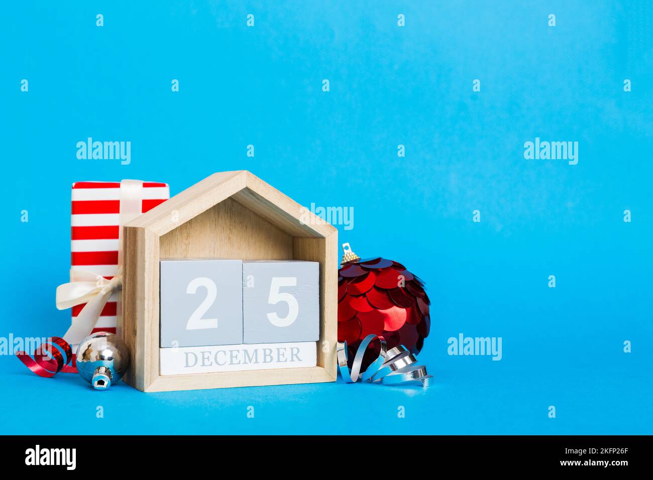 25 december. Christmas composition on colored background with a wooden ...