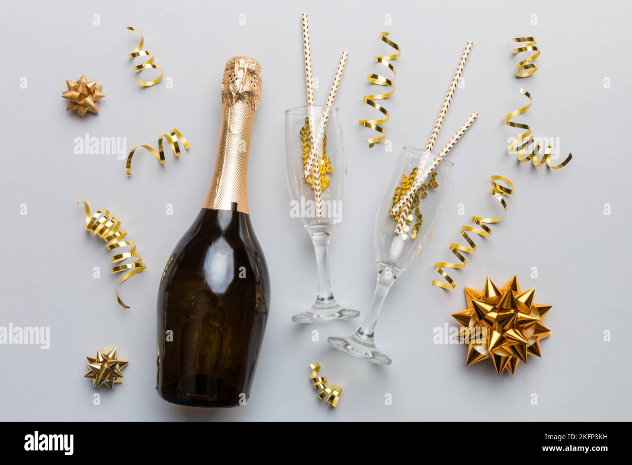 bottle of champagne with glasses and colorful confetti on colored ...