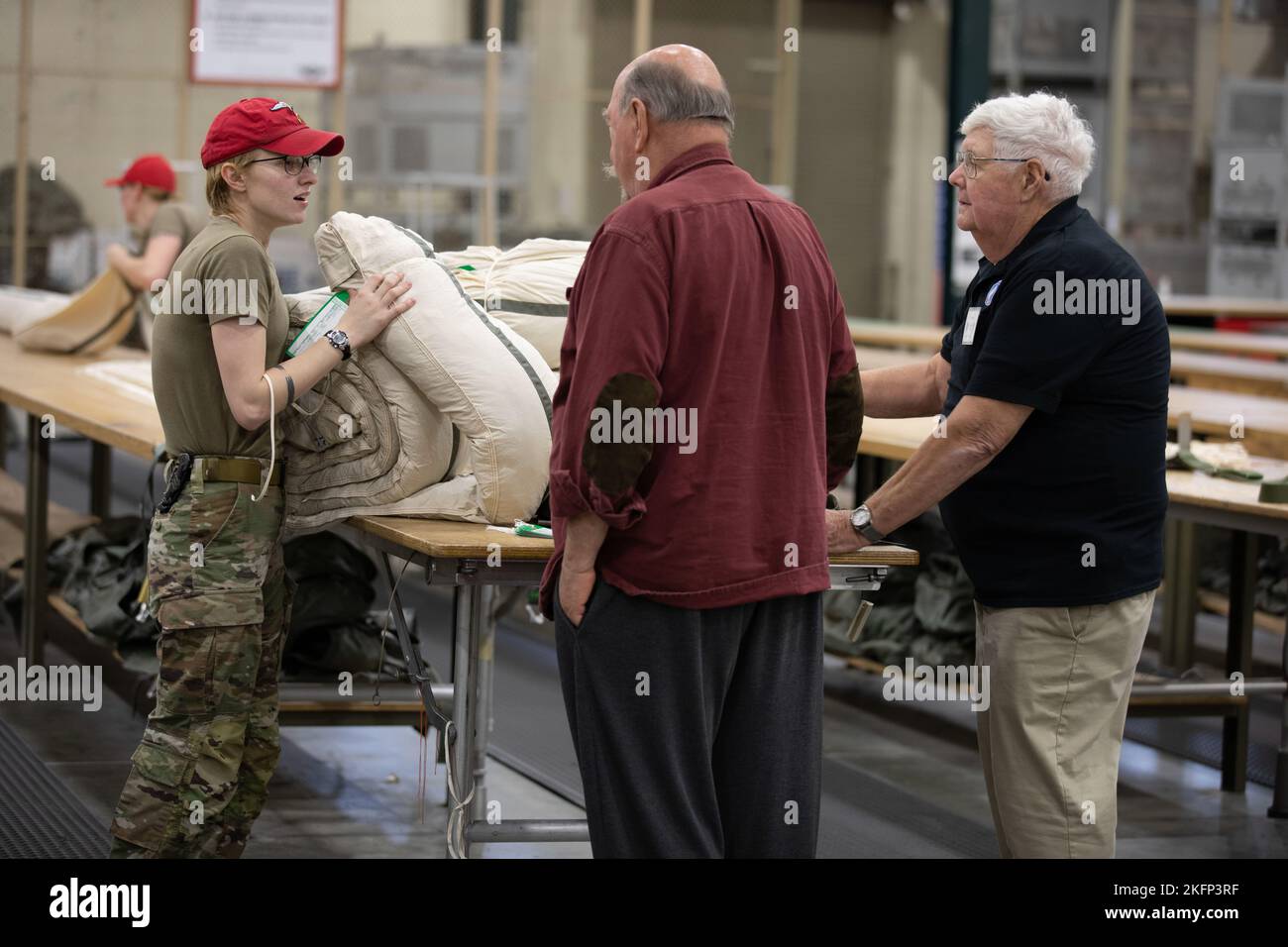 A U.S. Army parachute rigger with the 82nd Airborne Division talks to ...