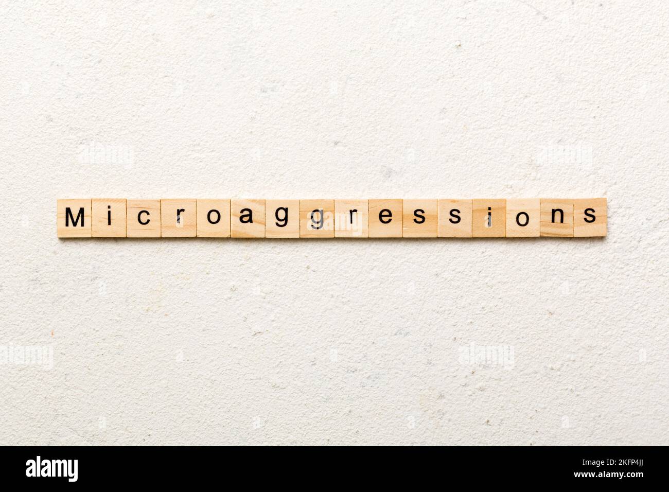 Microaggressions word written on wood block. Microaggressions text on ...