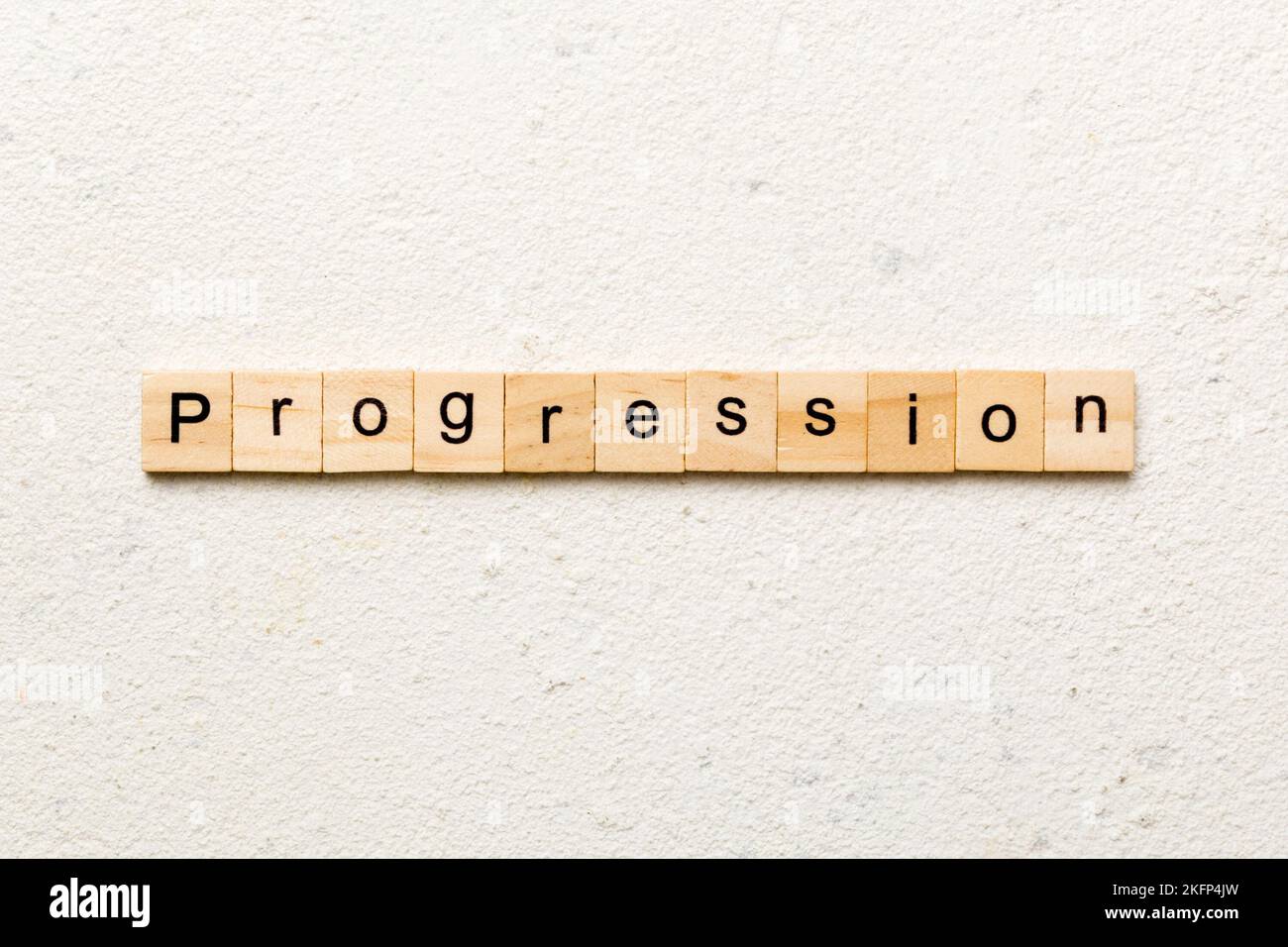 progression word written on wood block. progression text on cement ...