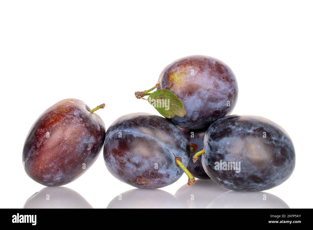 Several ripe organic plums, close-up, isolated on a white background ...