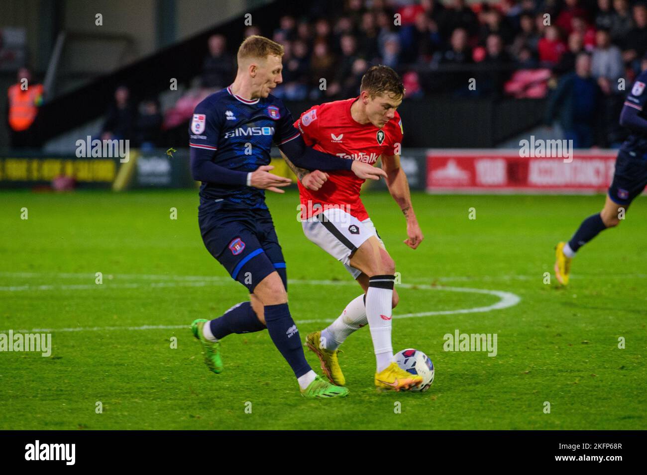 Callum Guy of Carlisle United trips Elliot Watt of Salford City during ...