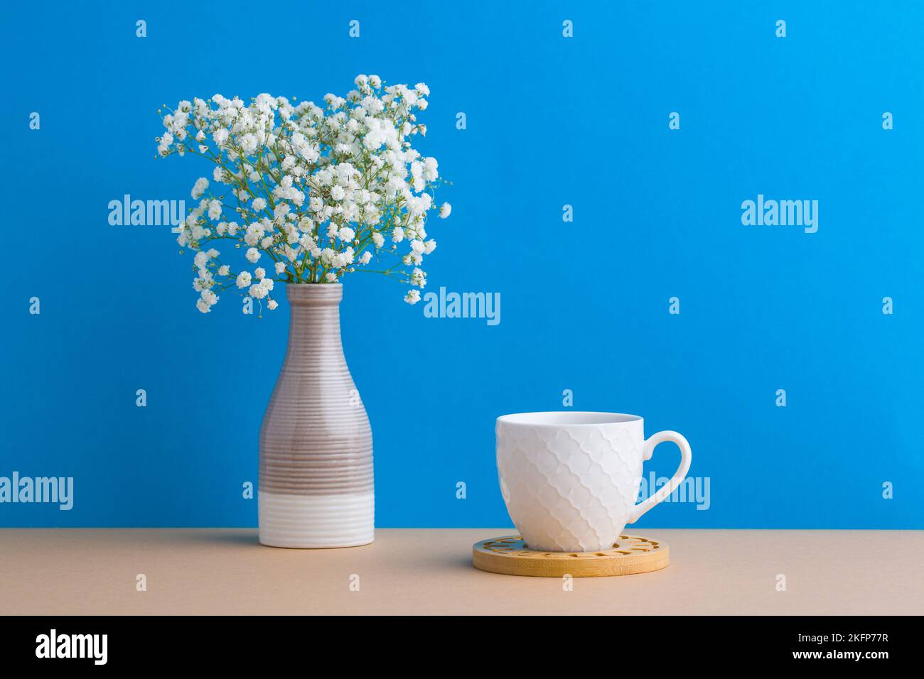 Small white flowers on a blue background. White flowers in a vase ...