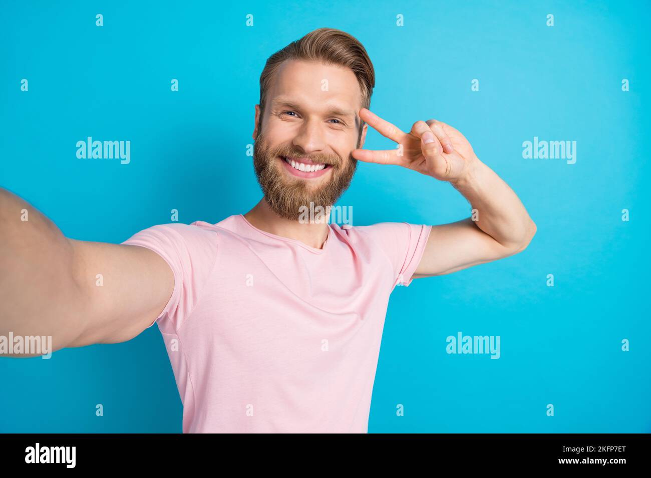 Photo portrait of nice young guy front camera streaming v-sign gesture ...