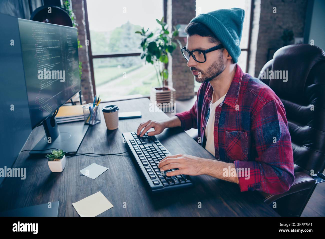 Photo of intelligent serious guy dressed eyewear typing code modern ...