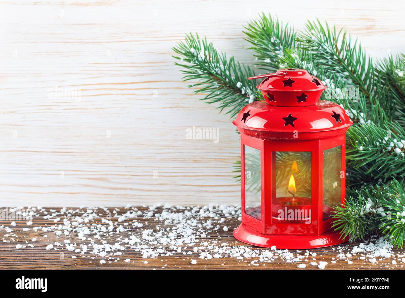 Red lantern with a burning candle and New Year decoration over snow and ...