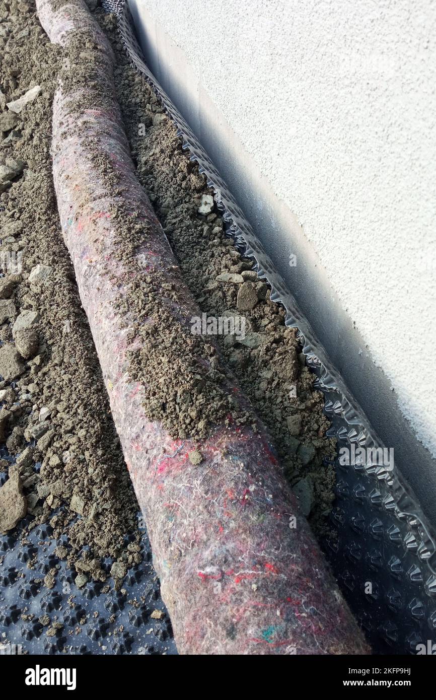 Workers carry out drainage works to drain the water around the house ...