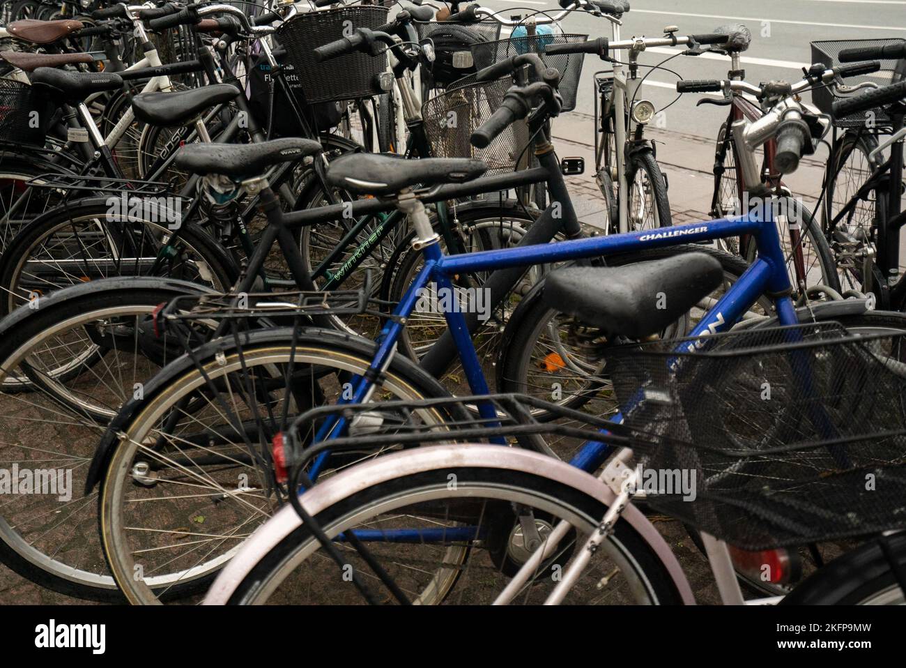 Lots of pedal bikes parked up on a street at a bicycle parking spot in ...