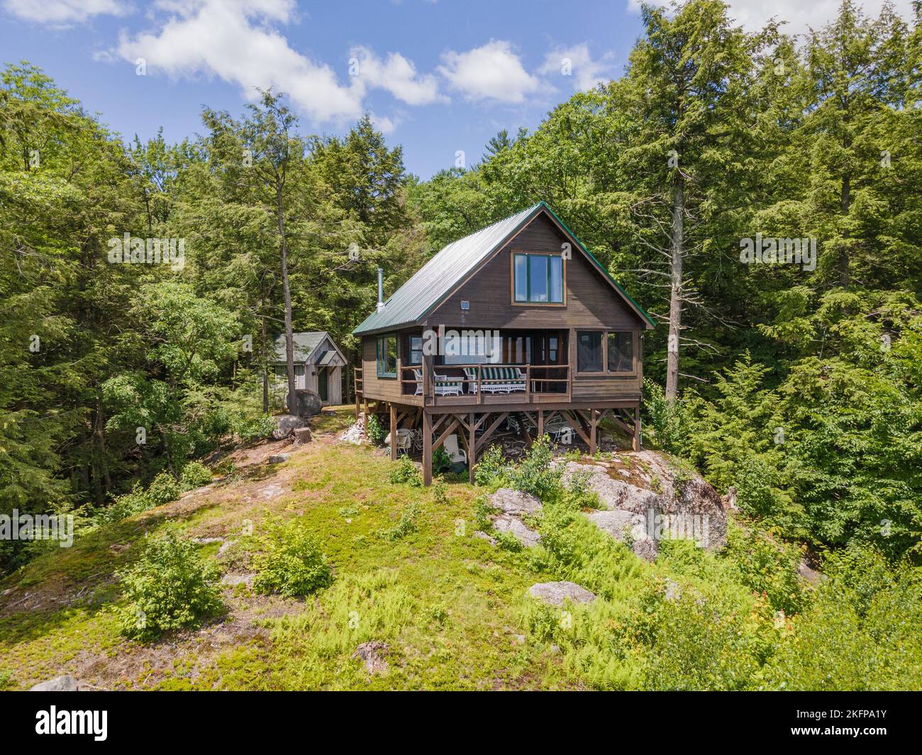 a wooden cabin surrounded by greenery in the daylight Stock Photo - Alamy