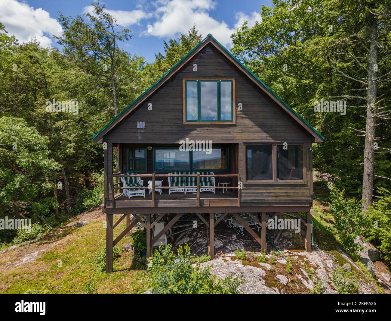 a wooden cabin surrounded by greenery in the daylight Stock Photo - Alamy