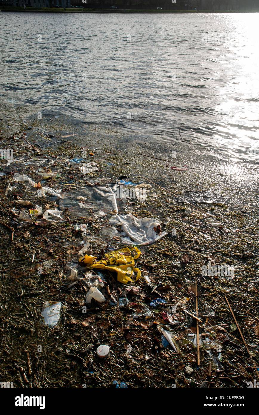 Plastic litter and other waste floating in water, washed up at ...