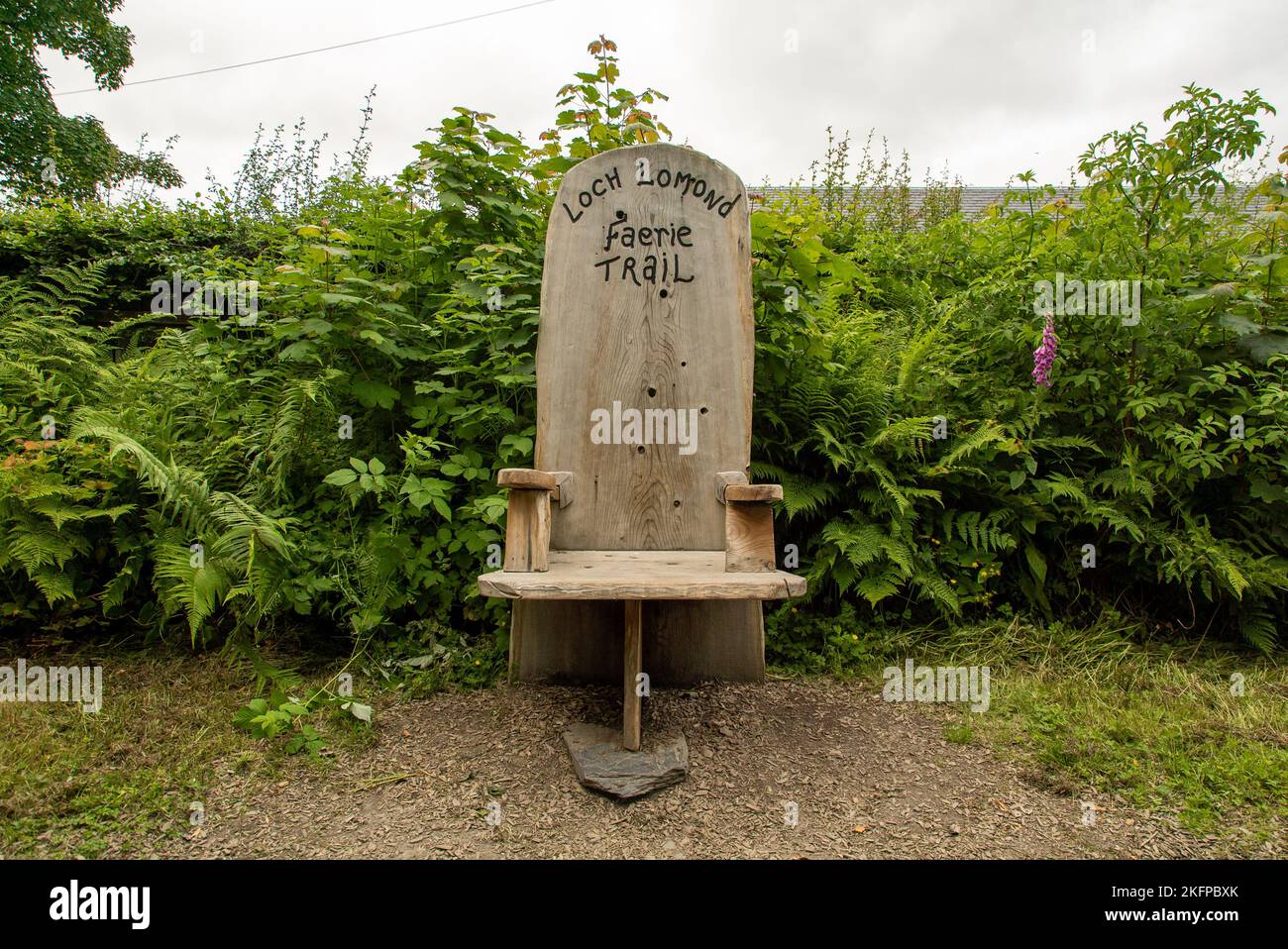 A wooden bench at the start of the Faerie Trail in Loch Lomond ...