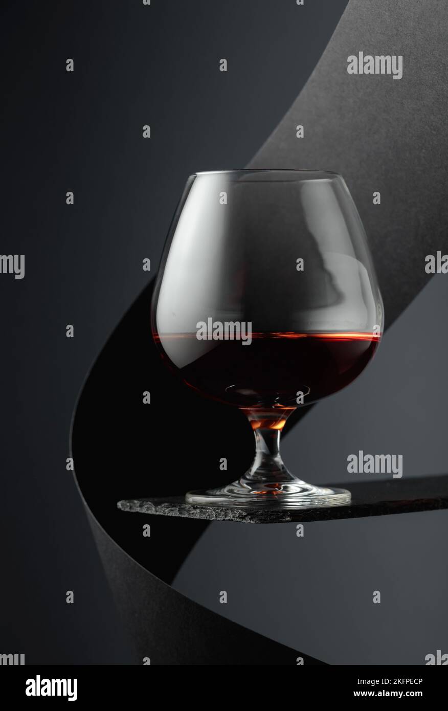 Snifter of brandy on a black background Stock Photo - Alamy