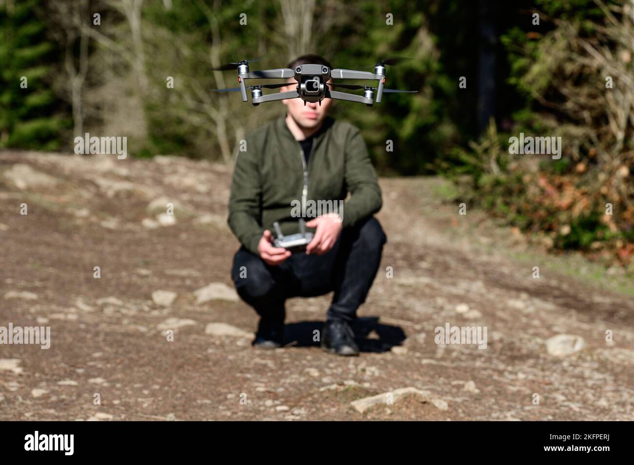 A man holds a remote control in his hands and controls the flight of ...