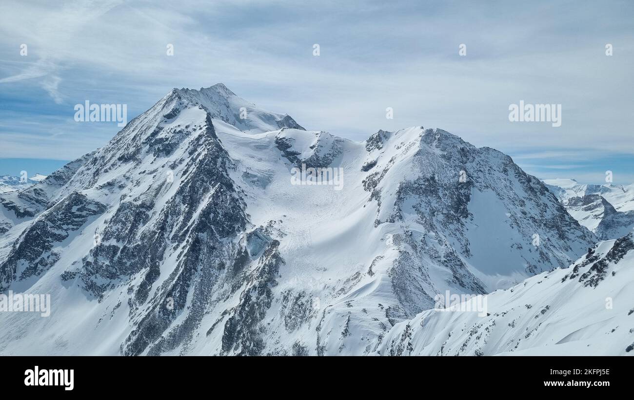 A beautiful view of a snowy mountaintop under the cloudy sky Stock ...