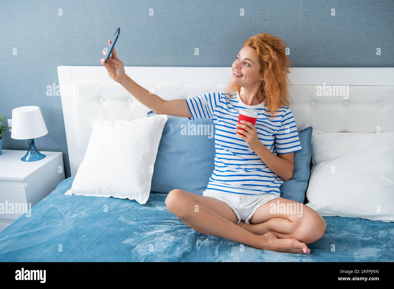 cheerful girl blogger with coffee making selfie on phone. selfie time ...