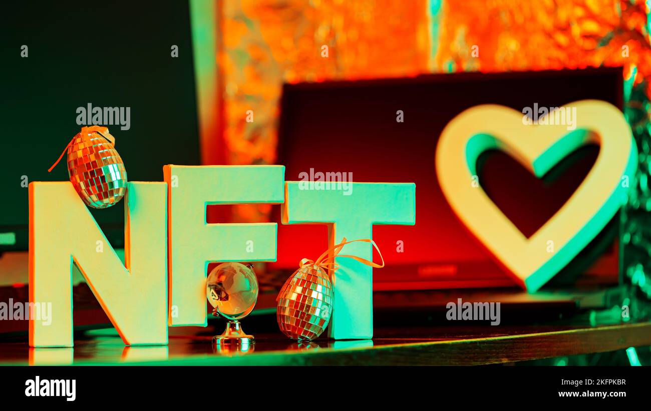 NFT inscription in neon light. NFT lettering at workplace with globe ...