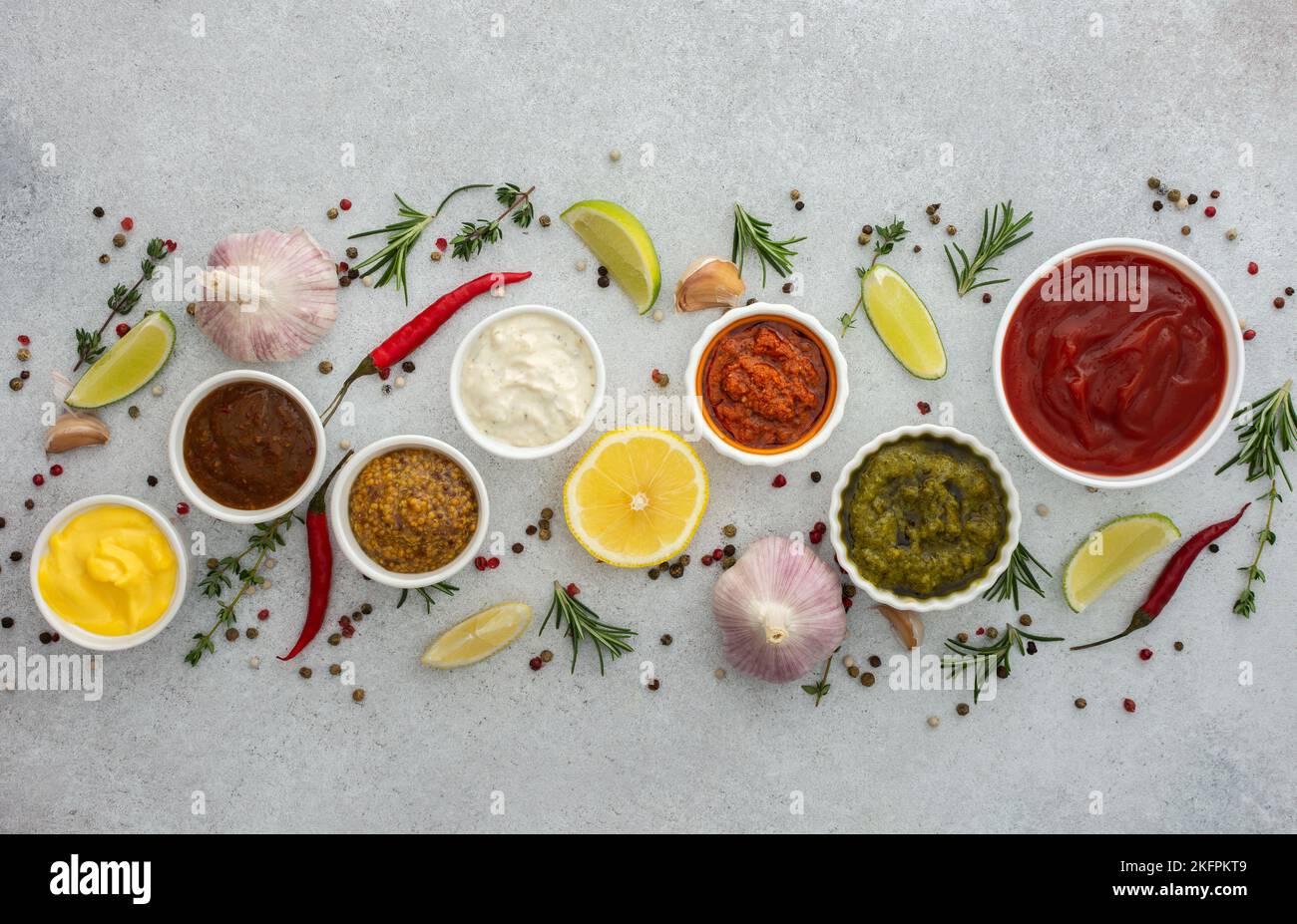 Different types of sauces in bowls with seasonings, rosemary and pepper ...