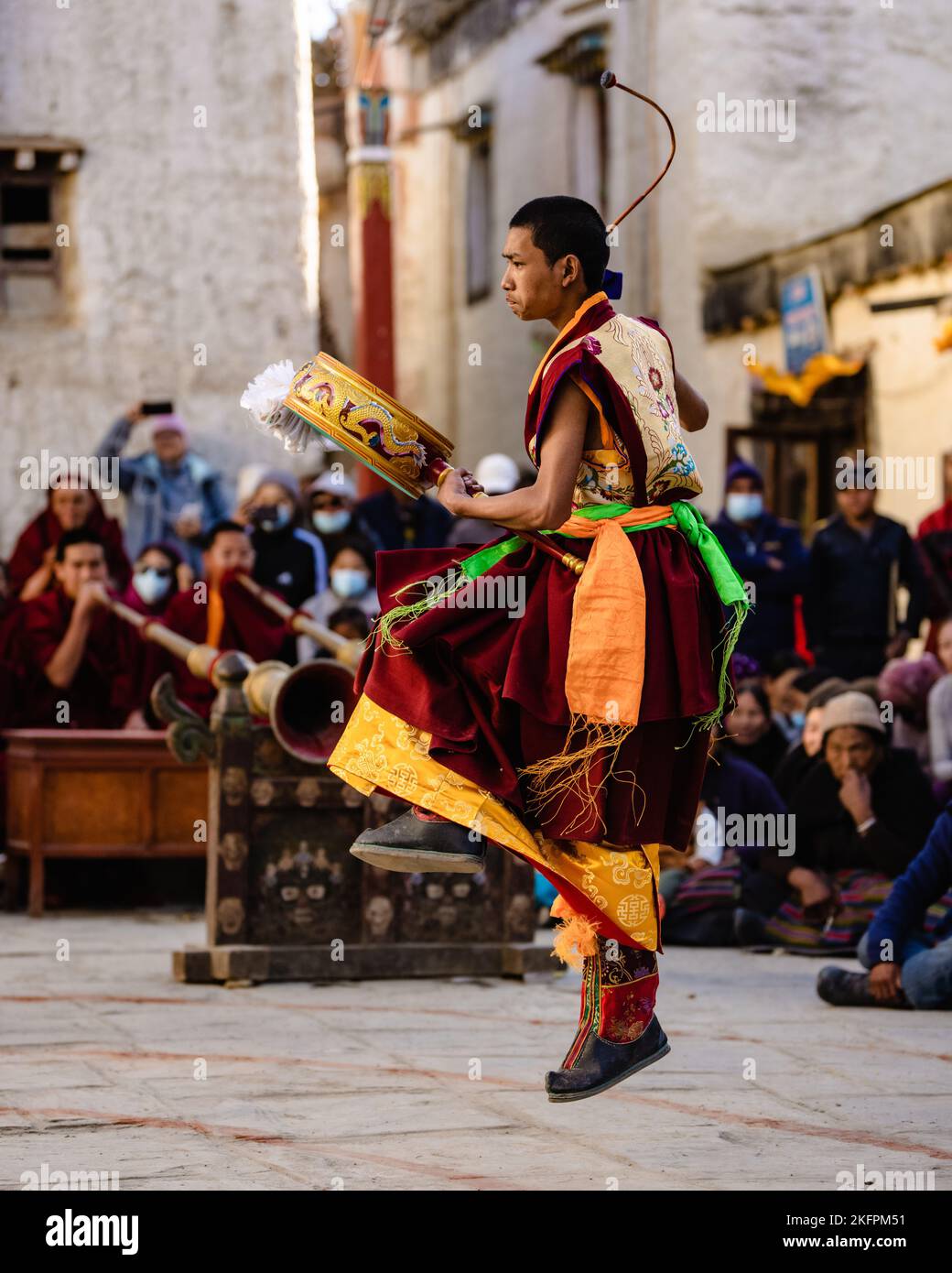 A Tibetan Buddhist playing drums and dancing in traditional clothing at ...