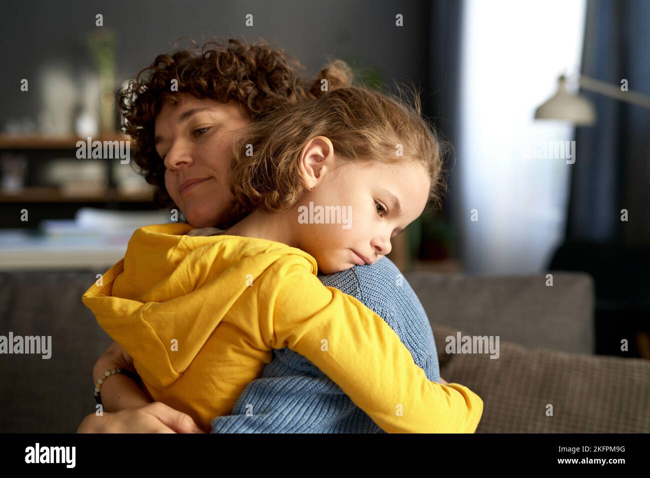 Young mom embracing and calming her child while he in bad mood or upset ...