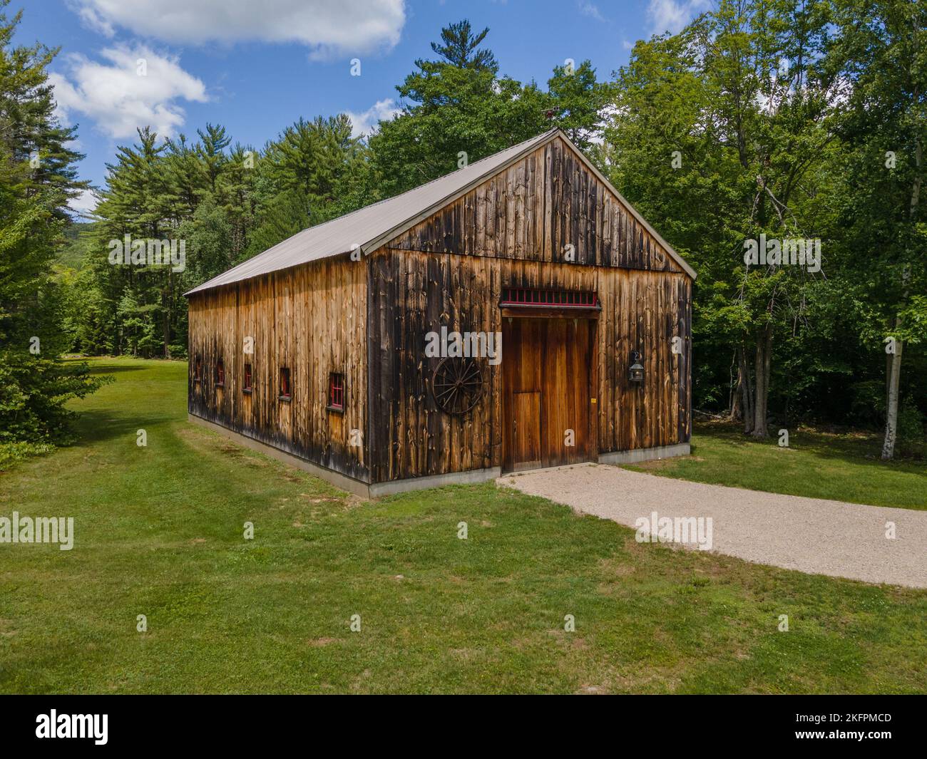 A rustic cabin in a green garden in the daytime with a blue sky and ...