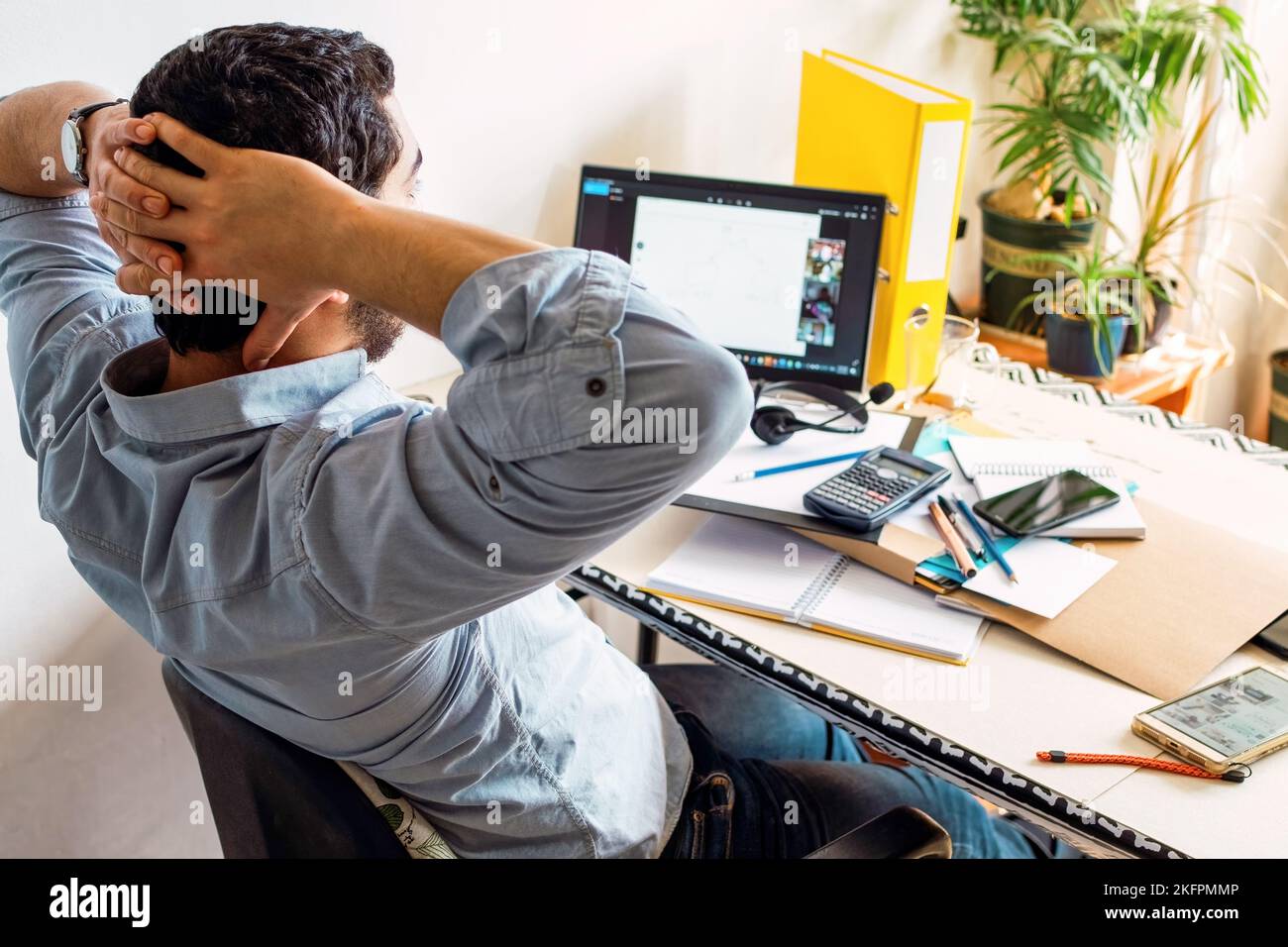 A Caucasian Male relaxing at a home work station with a laptop and ...