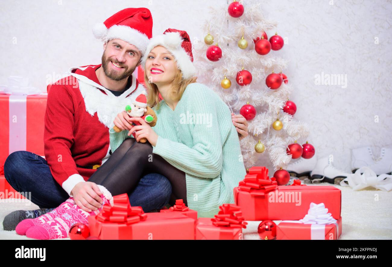 Loving woman and bearded man wear santa claus hat christmas tree ...
