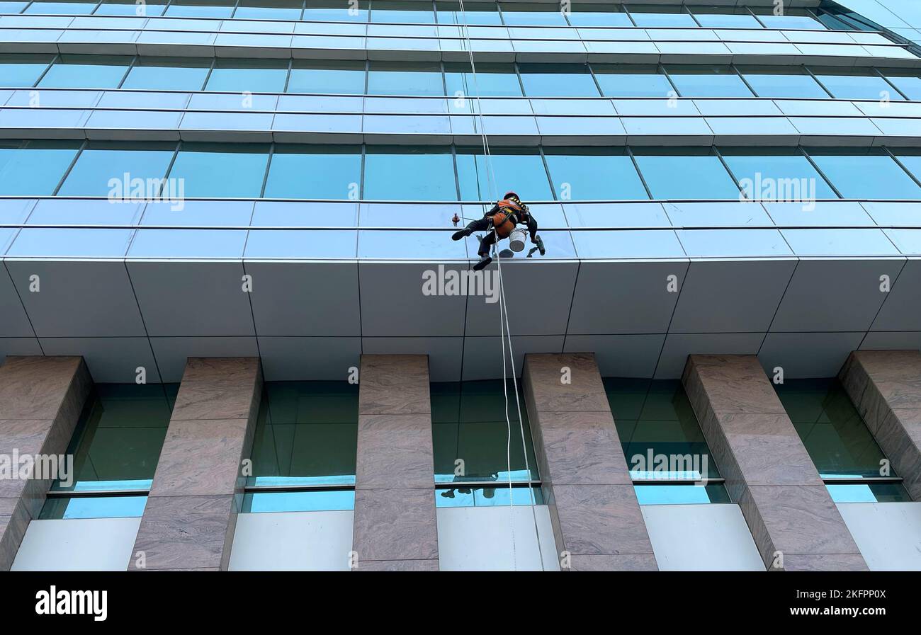 A professional skyscraper window cleaner hanging from a high building ...